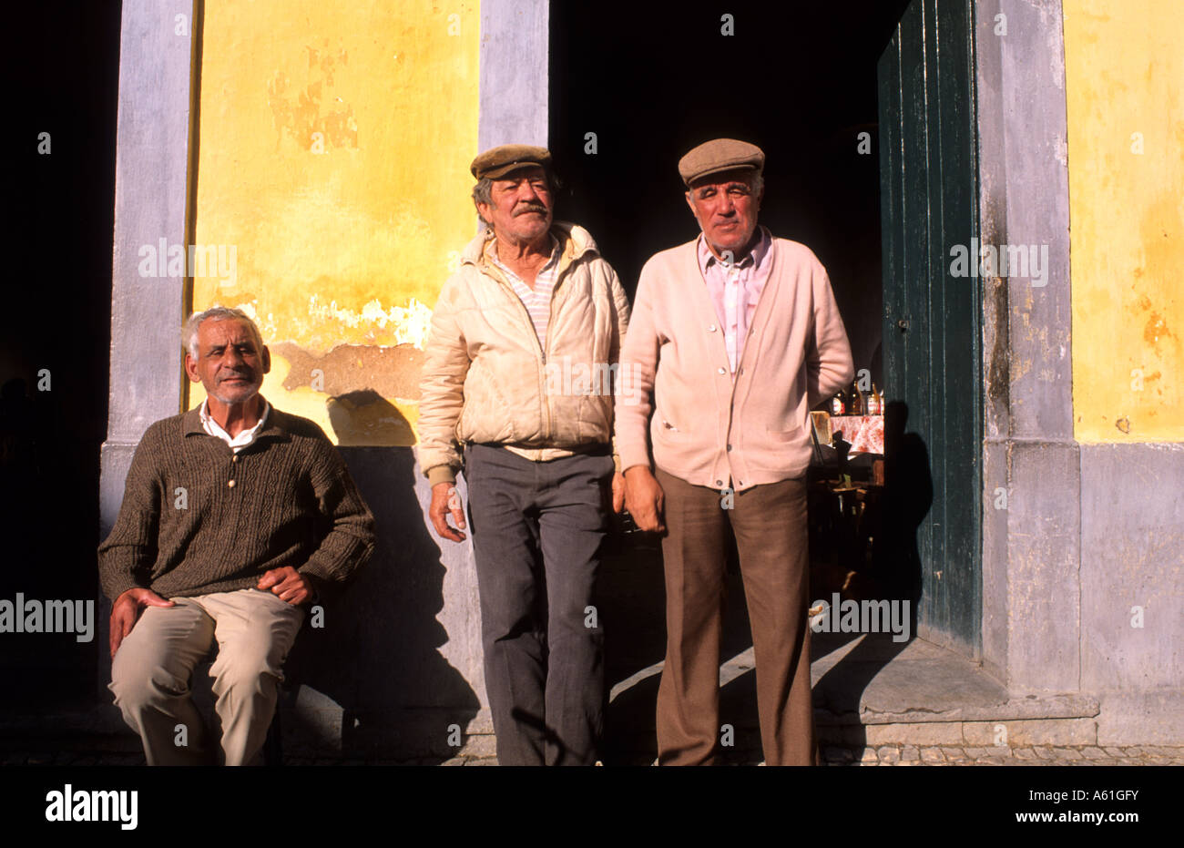 Tough and rough old fishermen relaxing at a bar in the village of Olmao ...