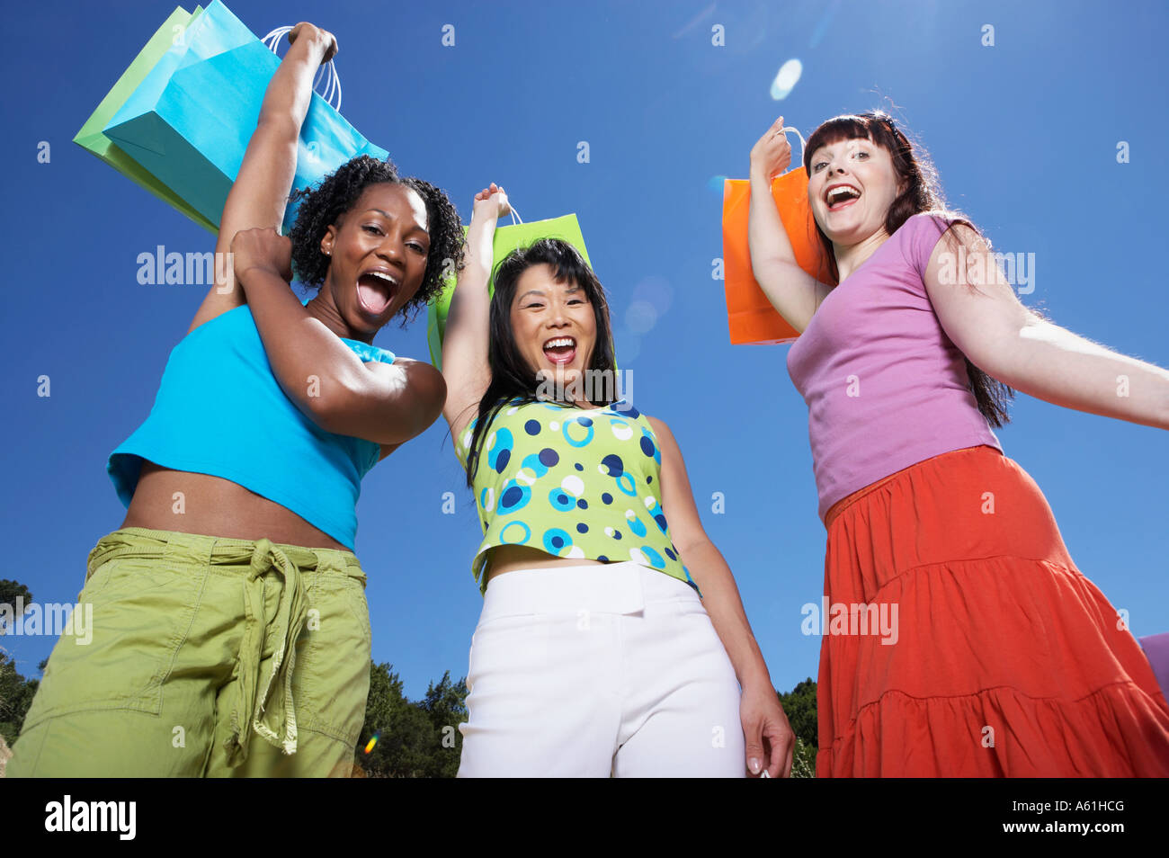 Three women holding shopping bags and cheering Stock Photo - Alamy