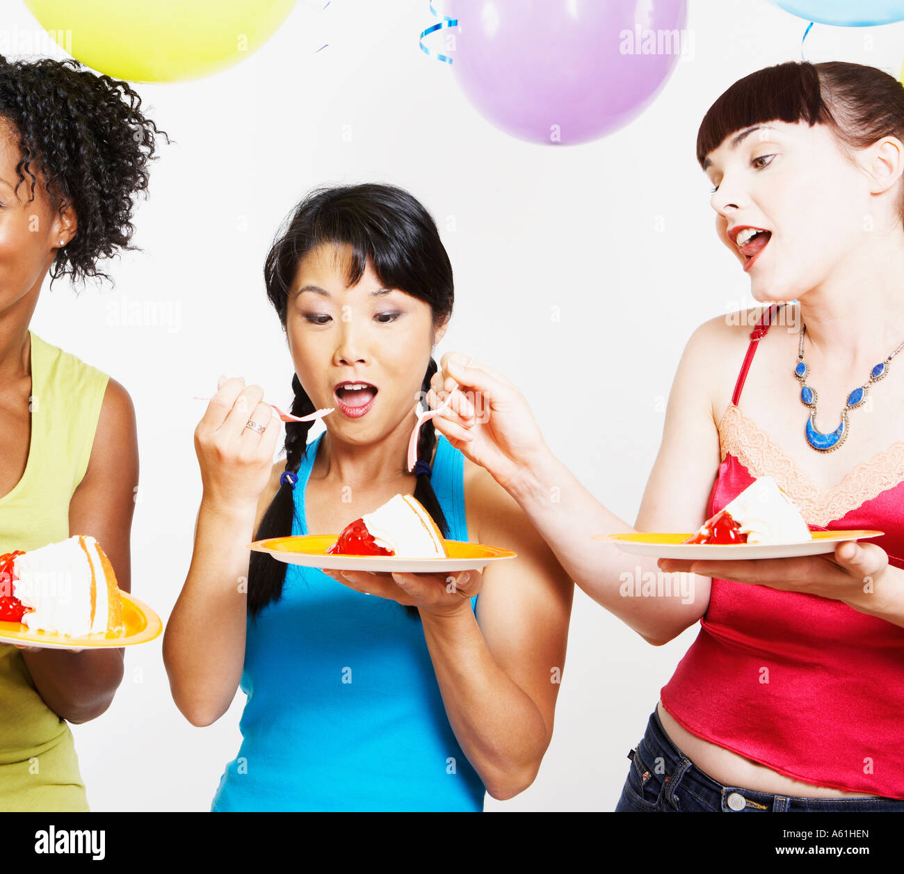 Three women eating cake at party Stock Photo - Alamy