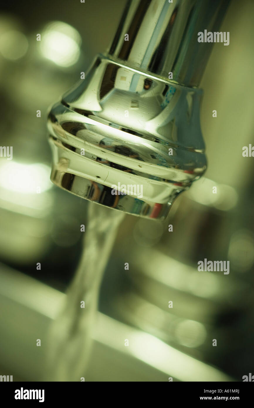 water pouring from a shiny chrome tap Stock Photo - Alamy