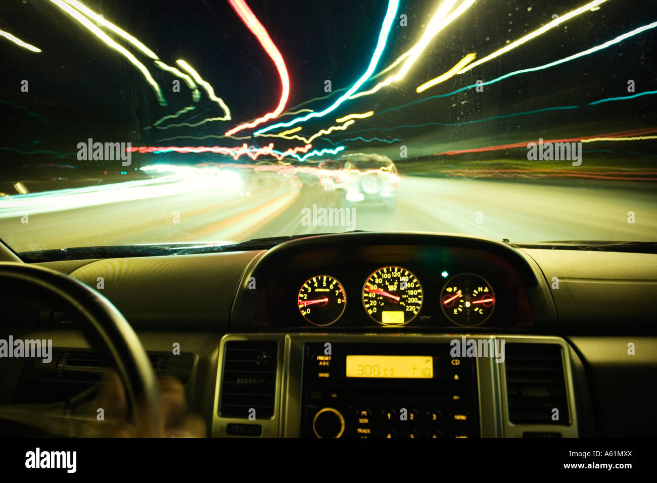 driving a car by night with light trails seen from the passenger ...