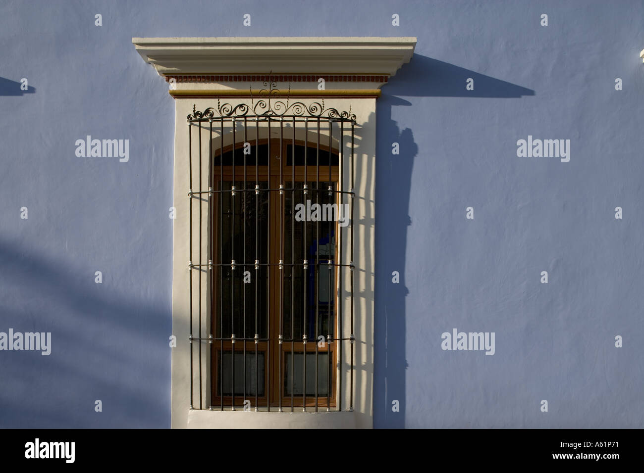 Mexico Oaxaca Morning sun lights grated window in a blue restored ...