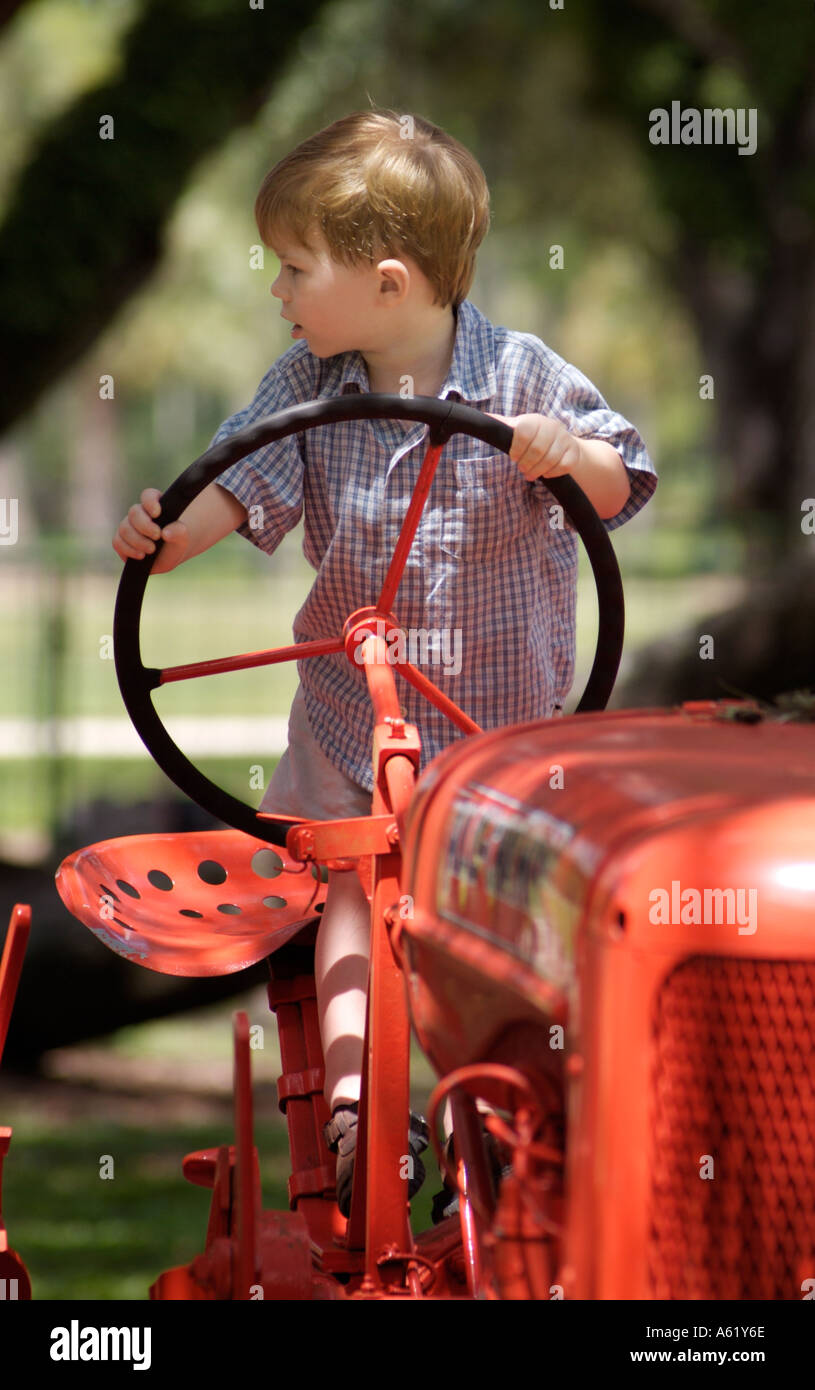 pml f07d tif young boy on old red farm tractor children playing ...