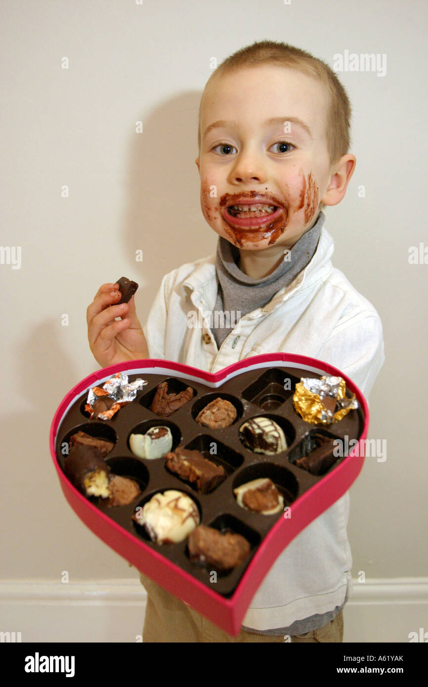 Valentines day. Young child with chocolate smeared all over his face ...