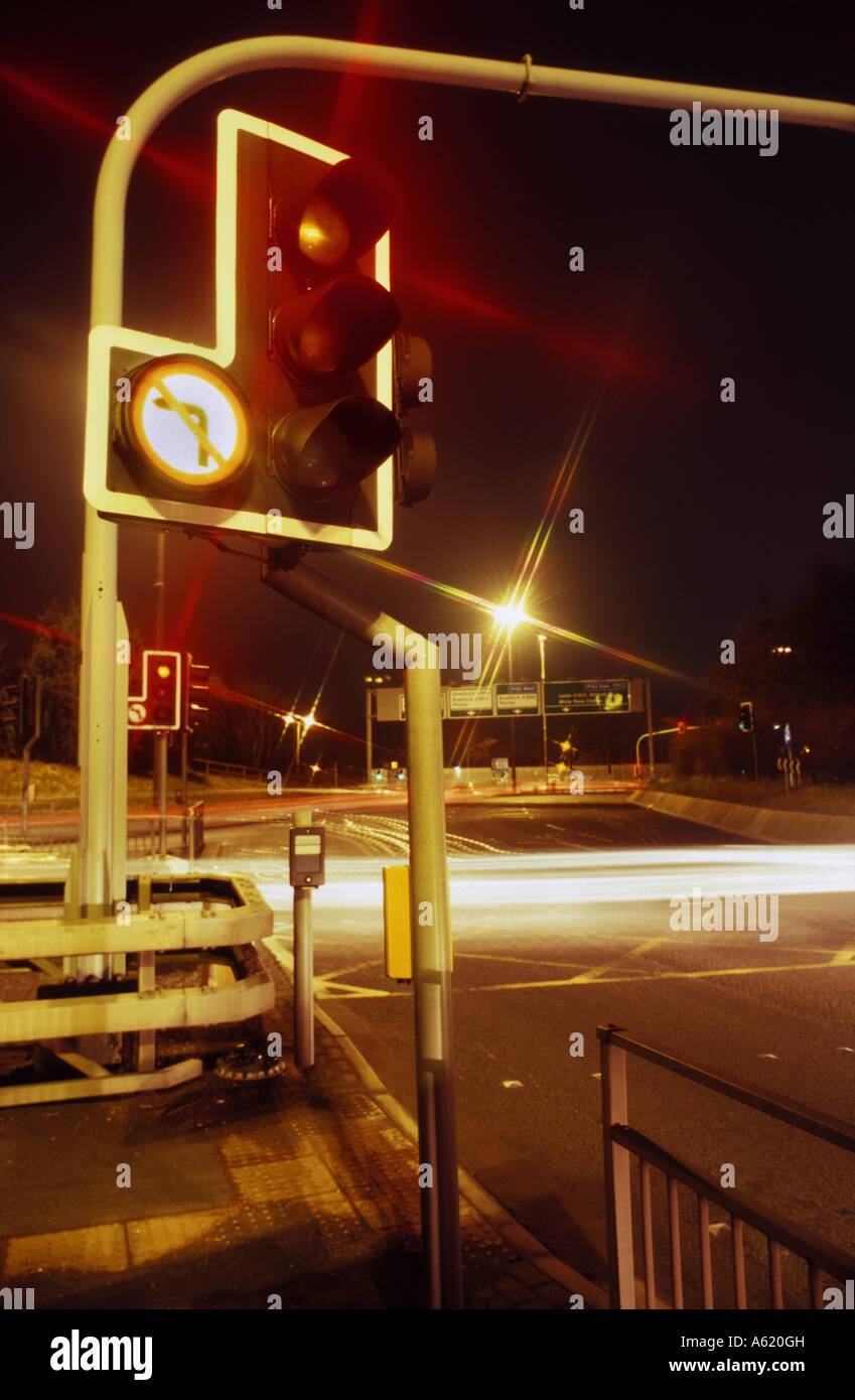 traffic passing red stop light at traffic light at night on roundabout ...