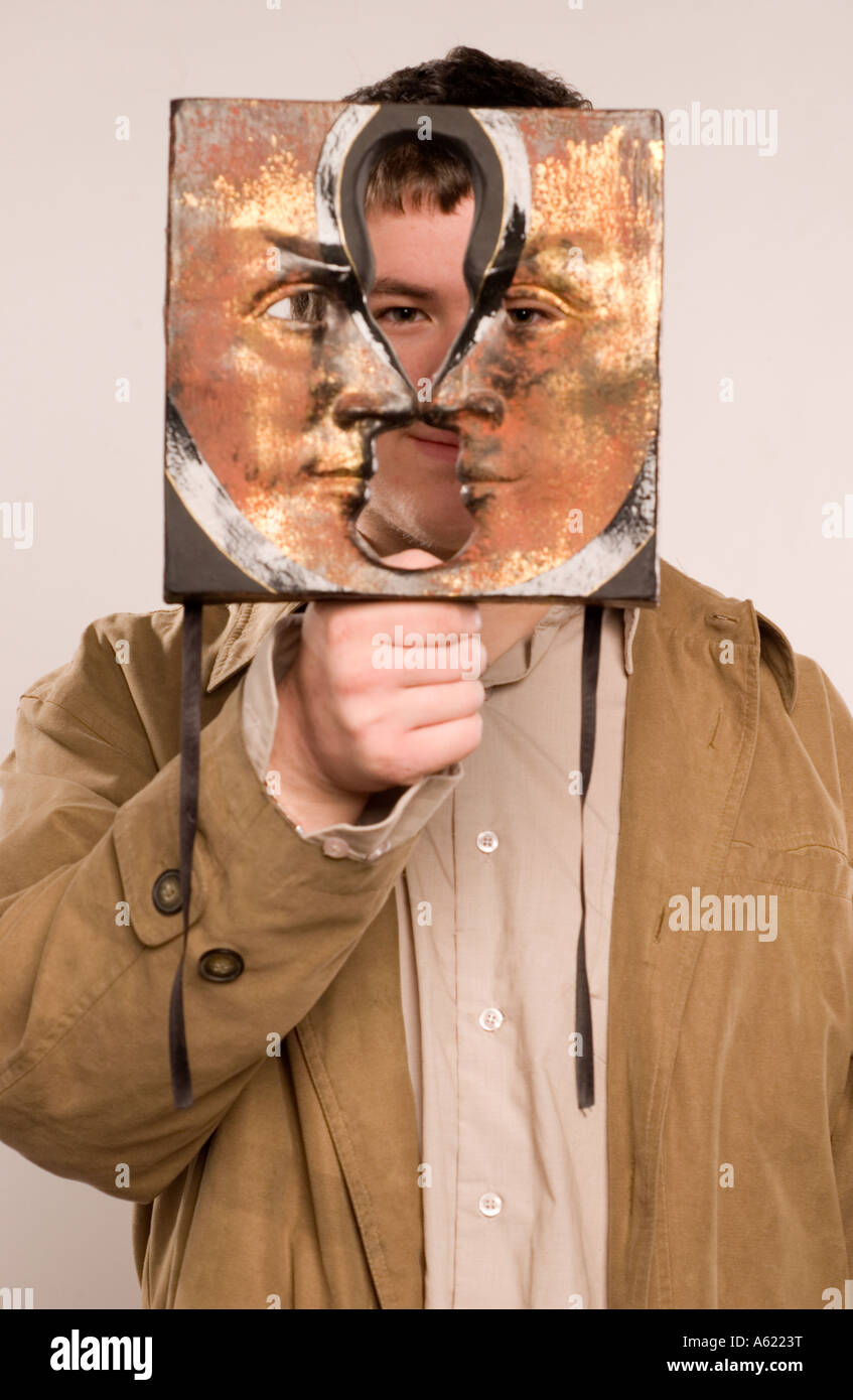 Young man holding mask on front of his face Stock Photo - Alamy