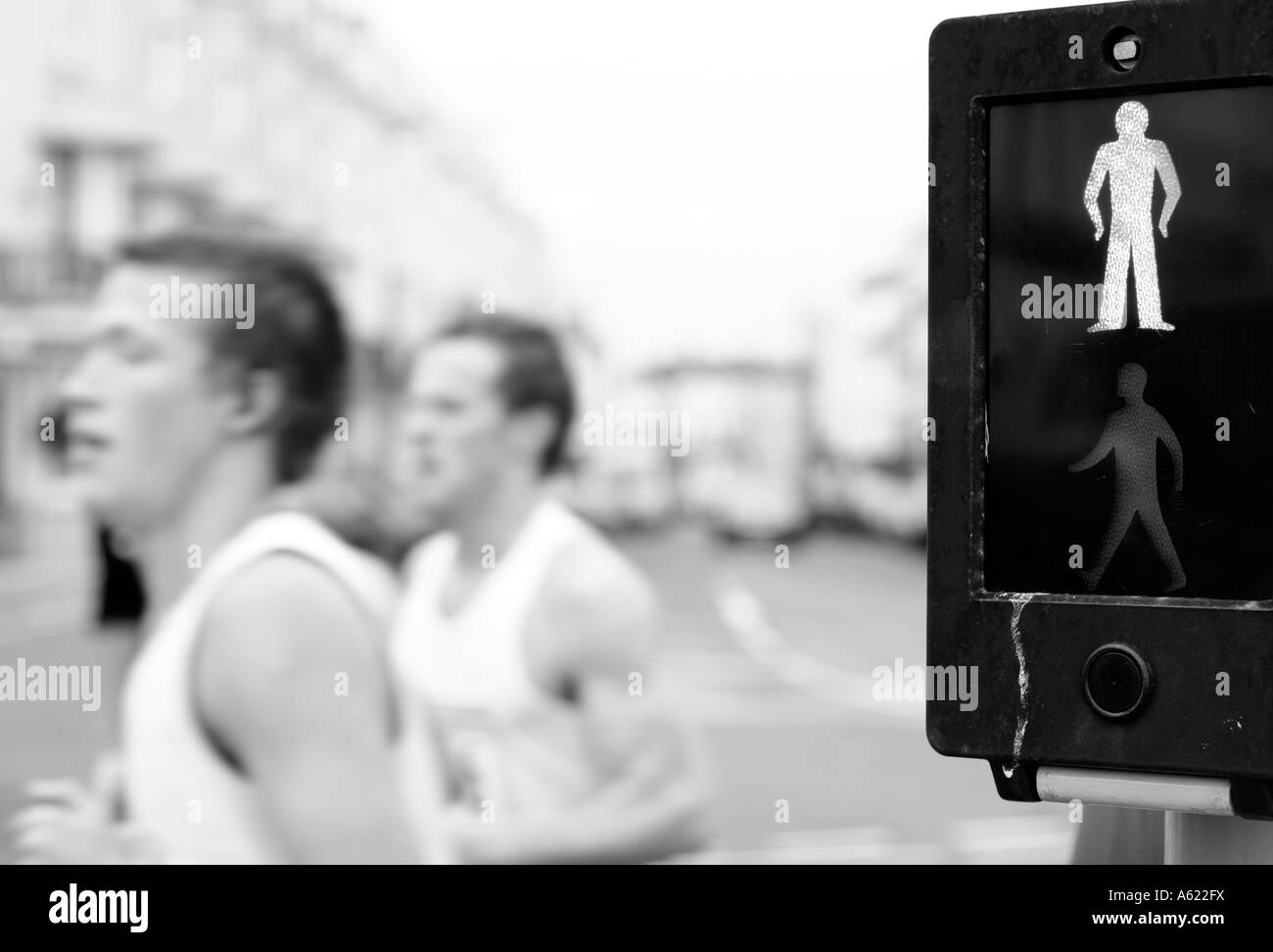 Two male athletes running past a pedestrian street crossing sign Stock ...