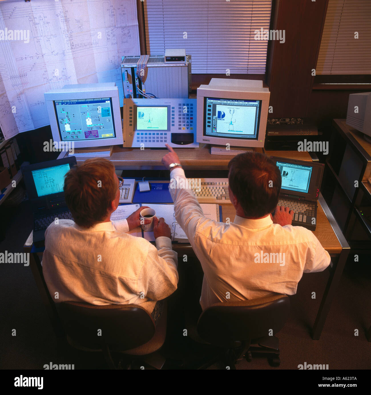 High angle view of two men working on computers in control room Stock ...