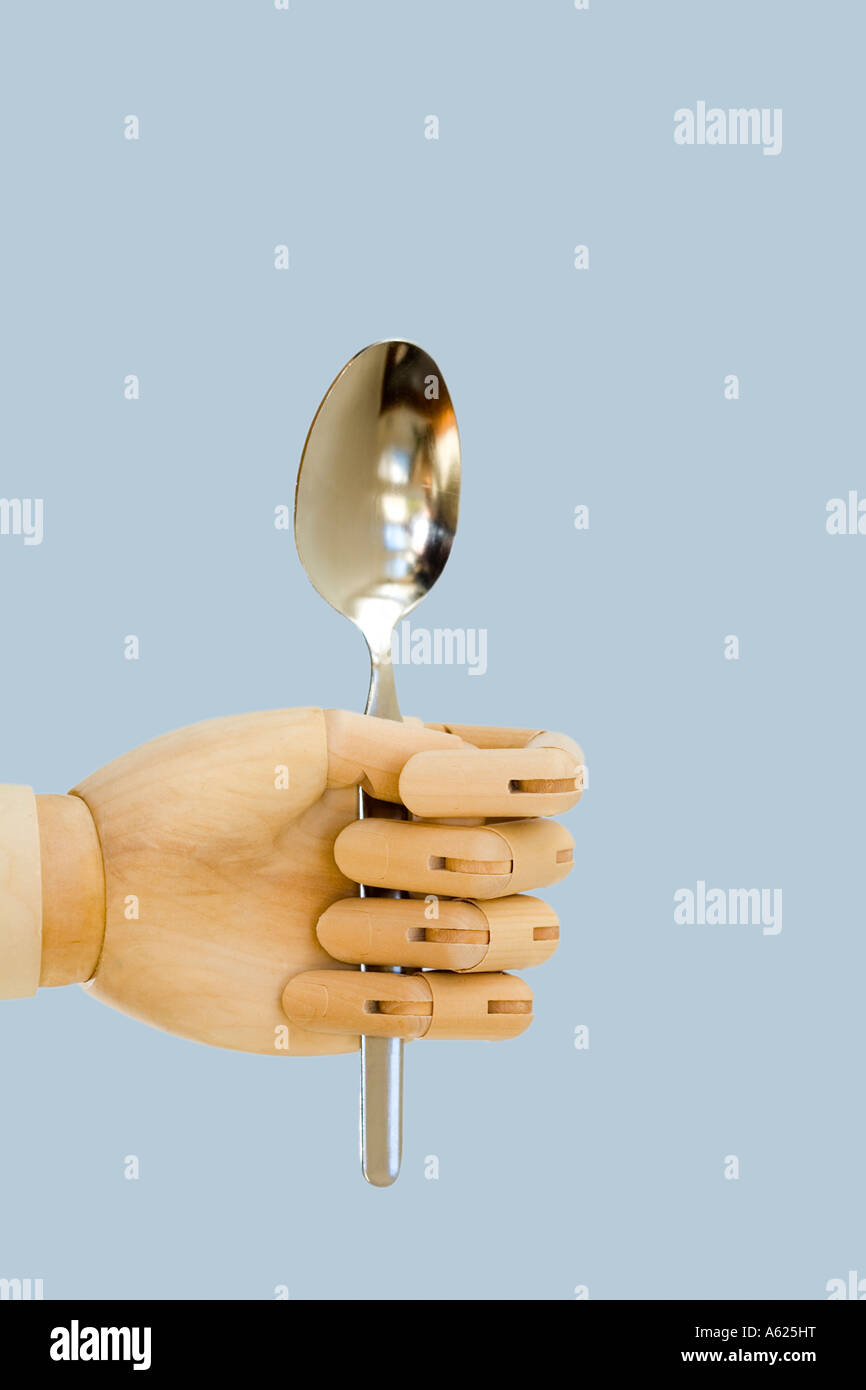 Wooden hand holding spoon Stock Photo - Alamy