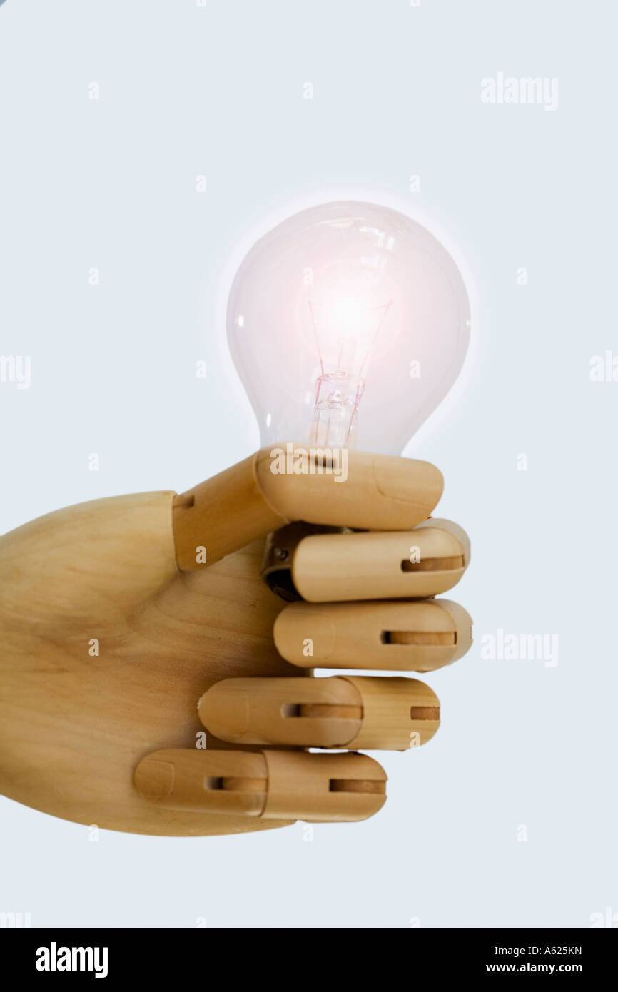 Wooden hand holding lit electric light bulb switch on Stock Photo - Alamy