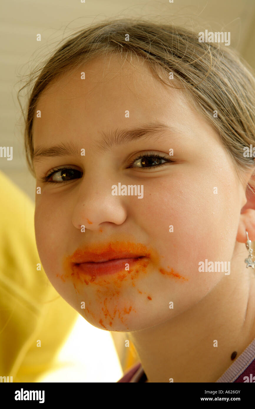 portrait of a young girl with a smudgy face after eating spaghetti ...