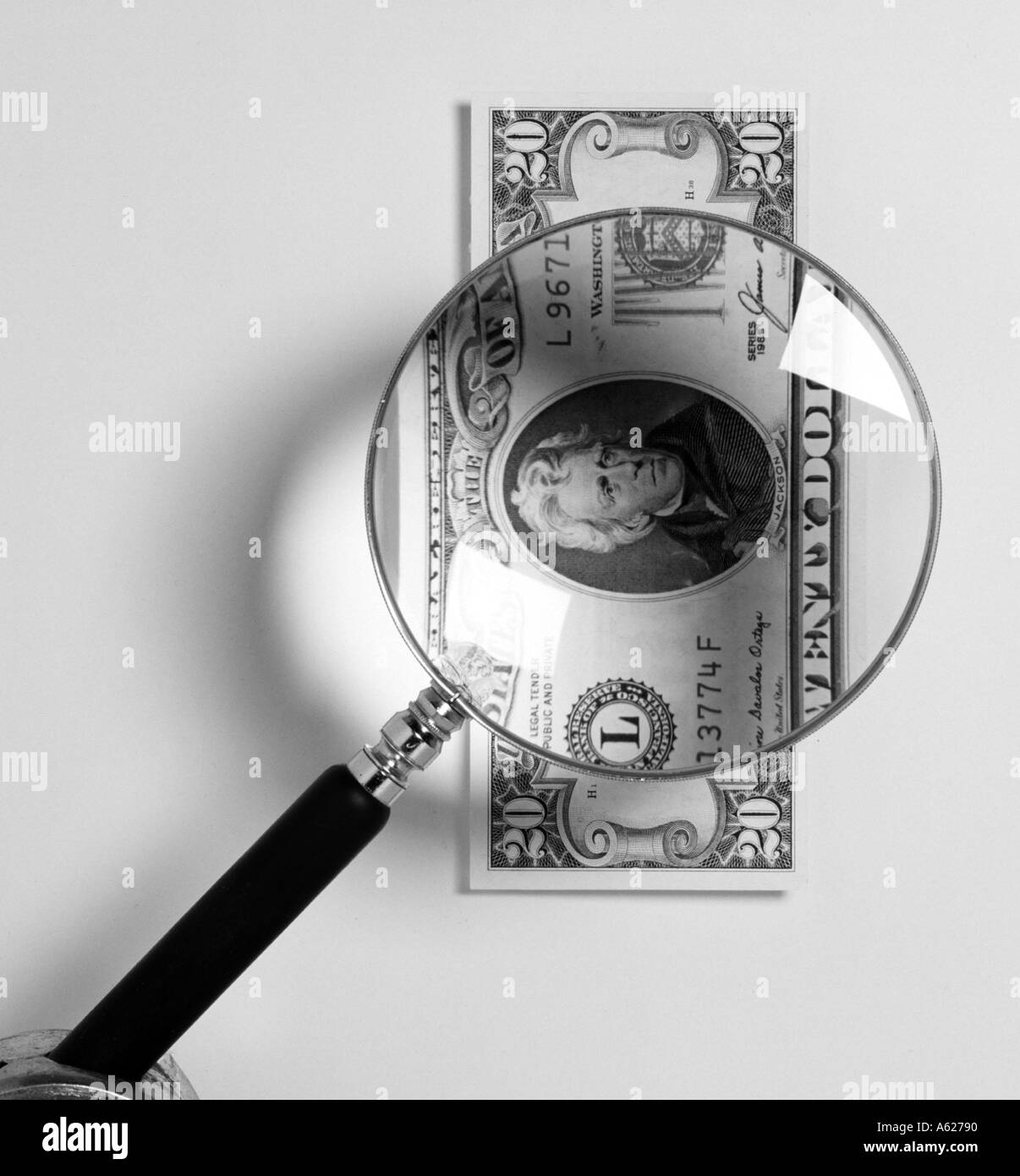 Magnifying glass focuses on money Stock Photo - Alamy