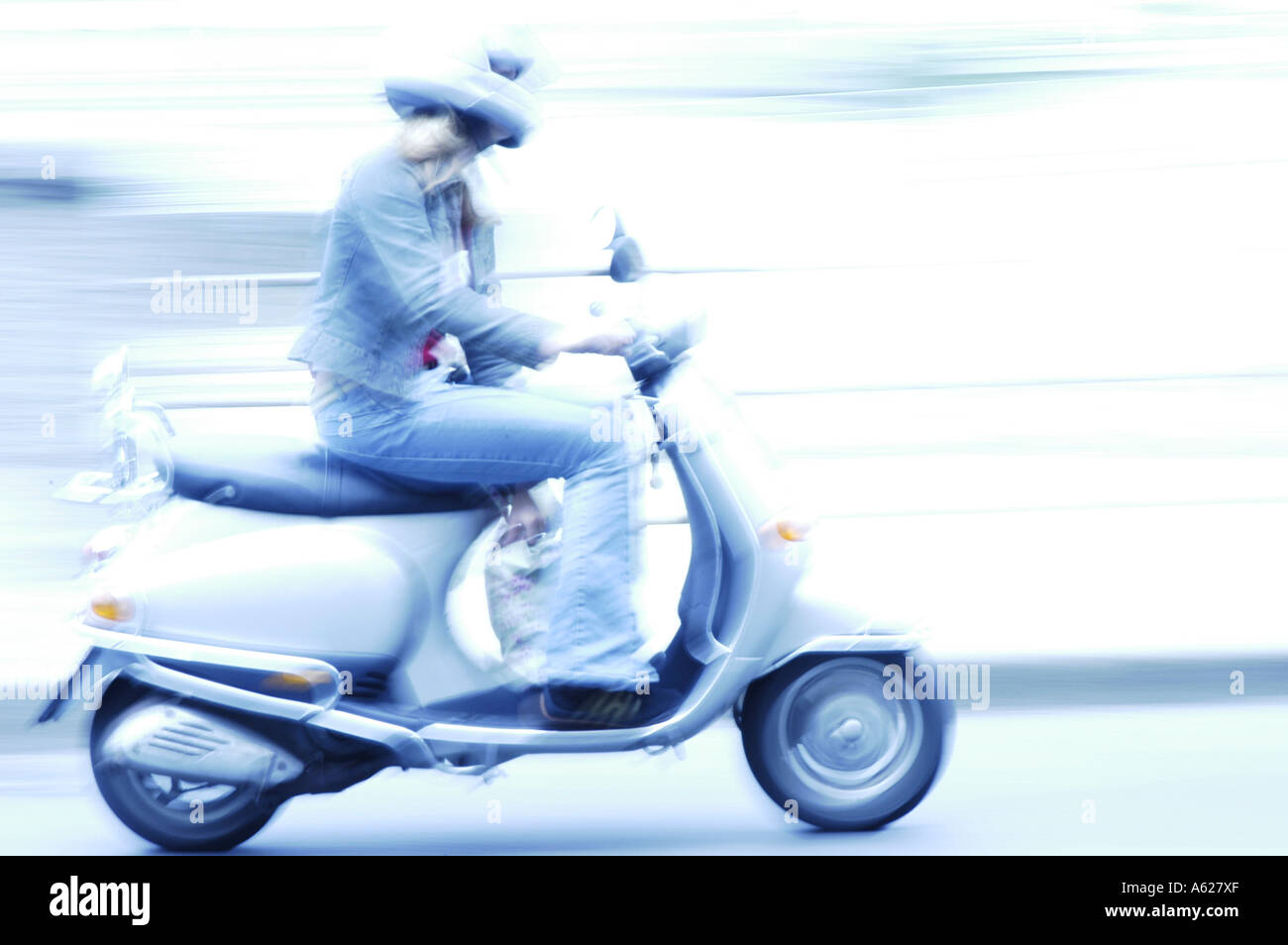 Side profile of woman riding motor scooter Stock Photo - Alamy