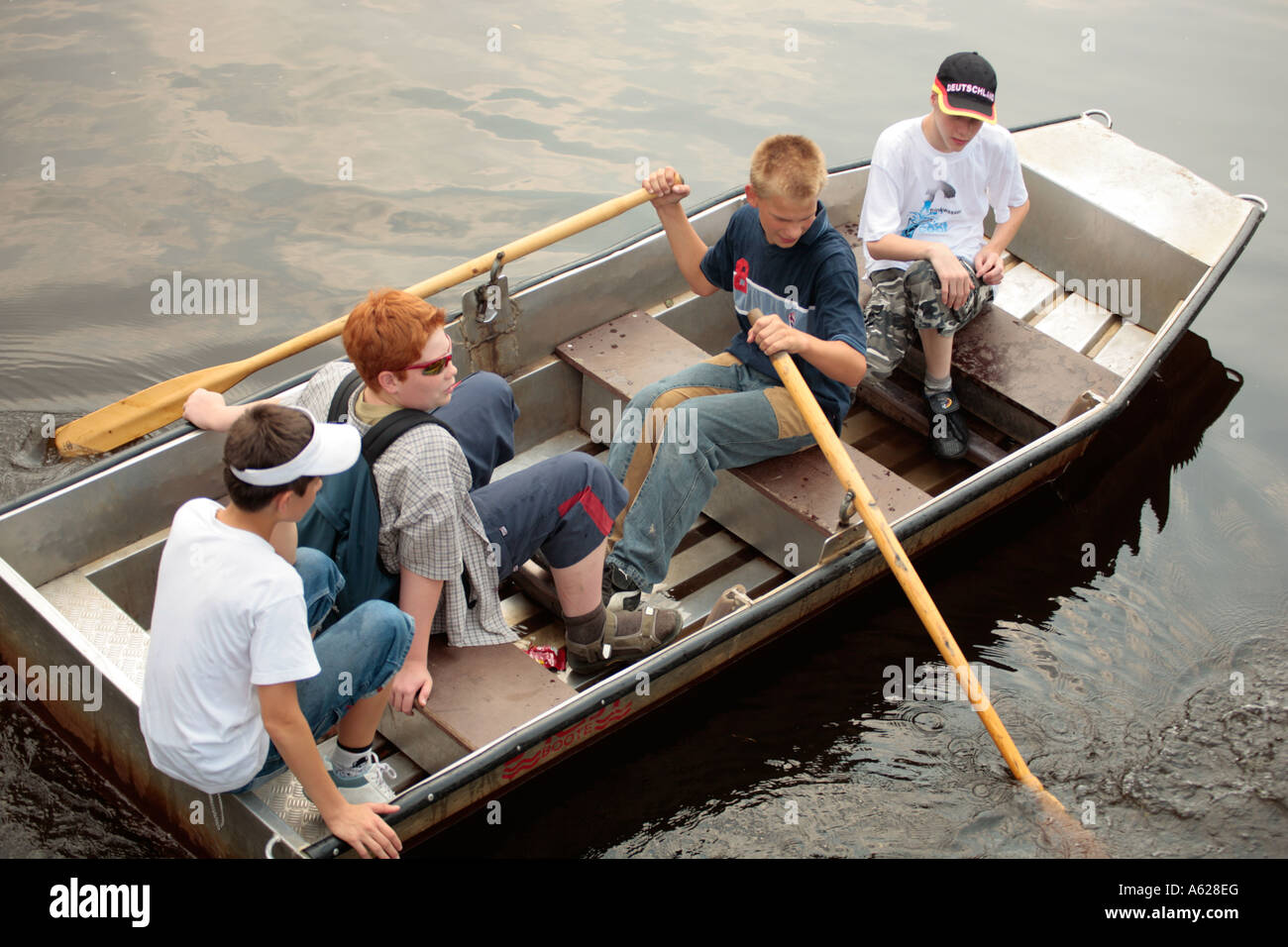 four young boys together in a rowing boat Stock Photo - Alamy