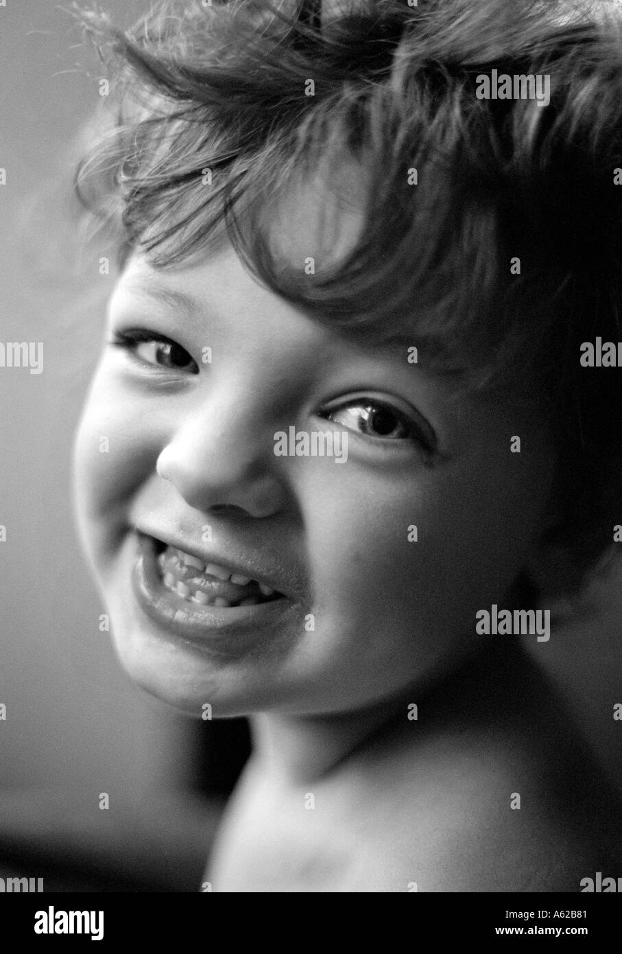 tight crop of child looking over his shoulder laughing Stock Photo - Alamy