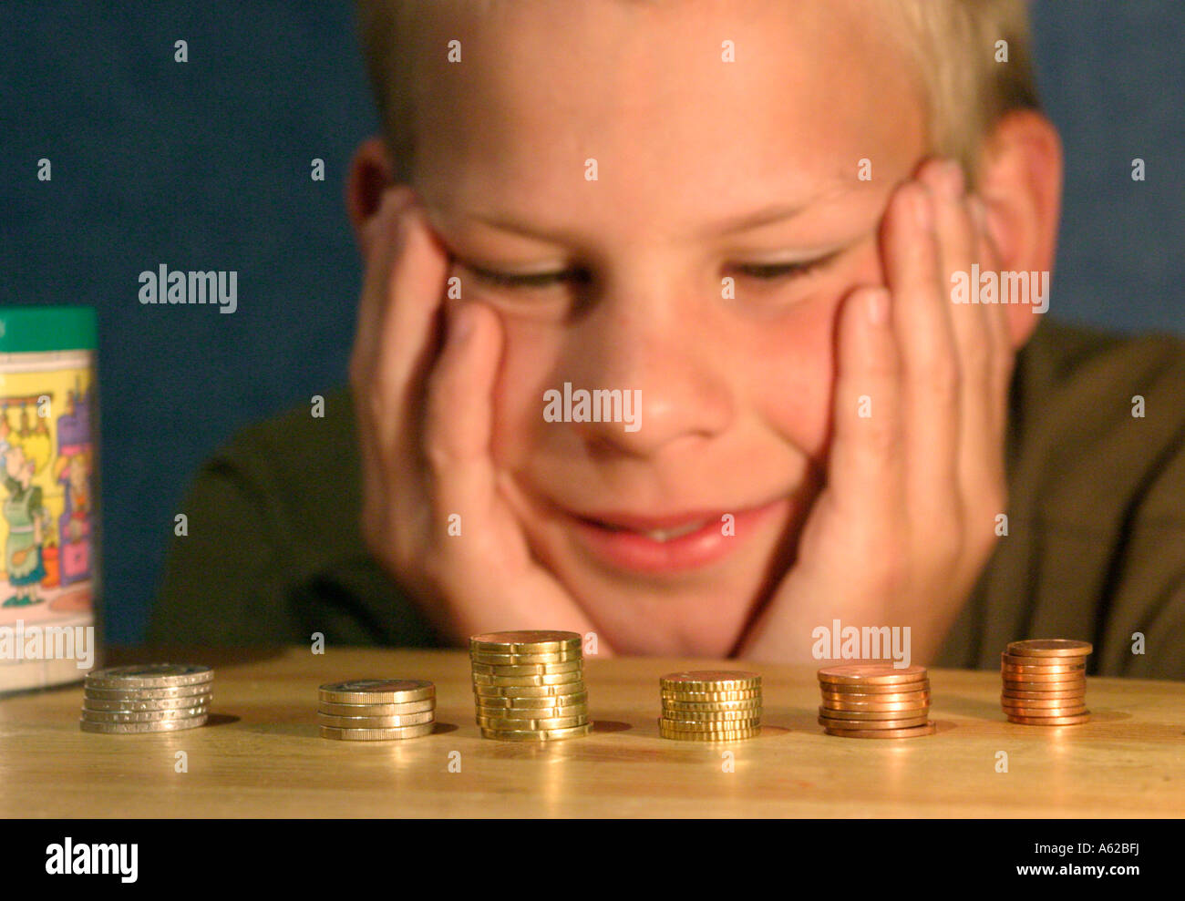 portrait of a young boy immersed in looking at the money he has saved ...