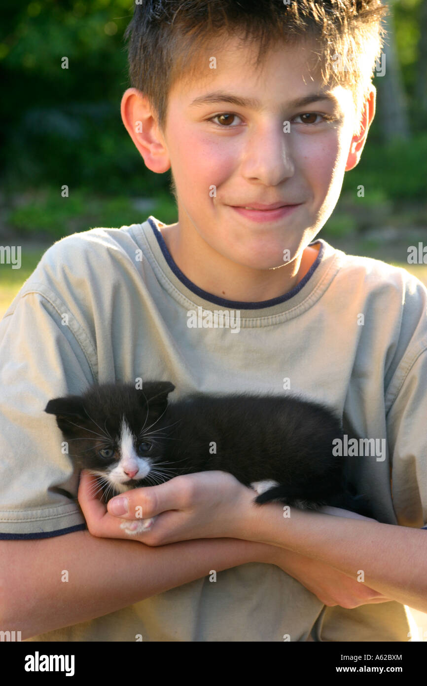 portrait of a young boy holding a kitten in his arms Stock Photo - Alamy