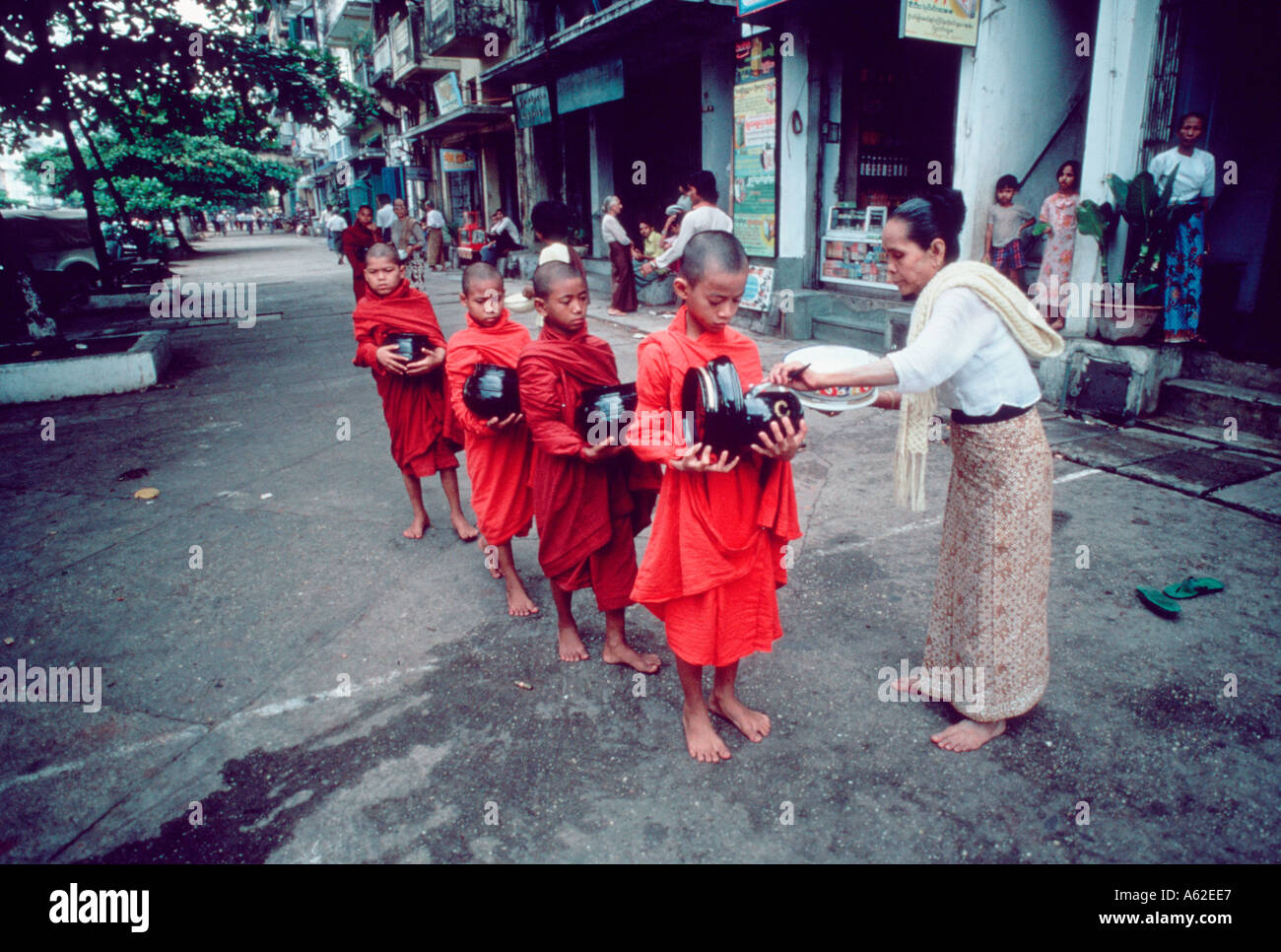 Giving rice to novice monks Rangoon Stock Photo - Alamy