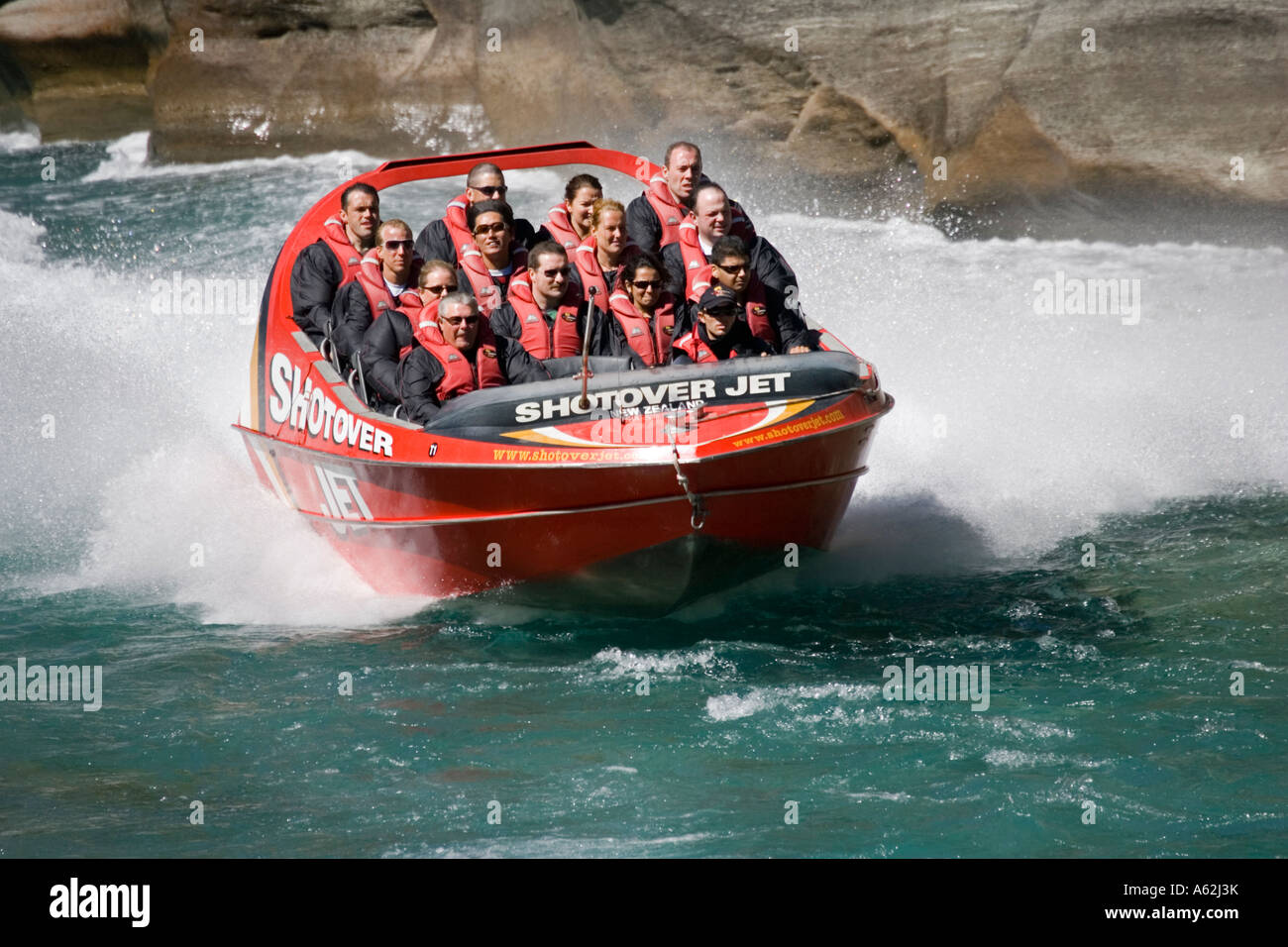 Red Shotover jet boat skimming through Shotover canyon near Queenstown ...