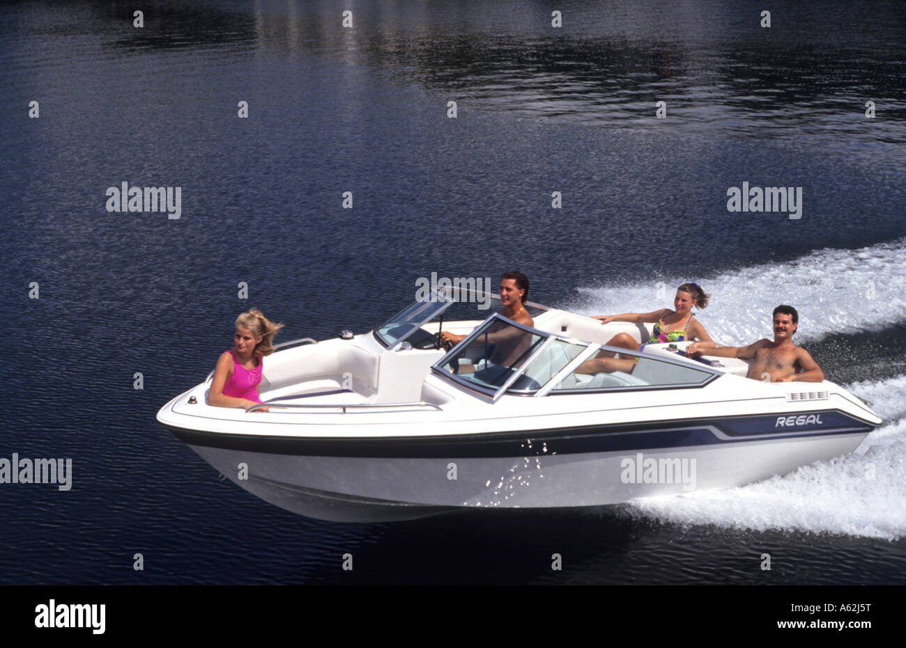 Couples running motor boat with wake and excitement as it moves thru ...