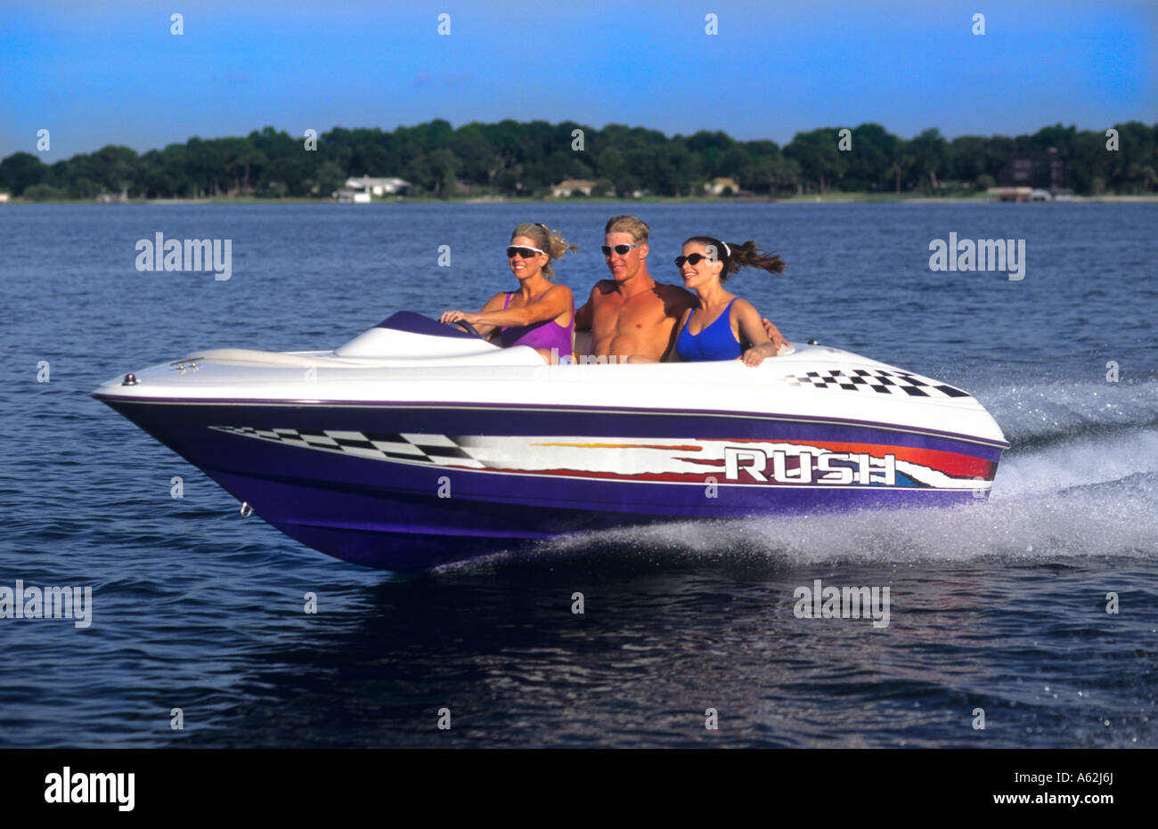 Couples running motor boat with wake and excitement as it moves thru ...