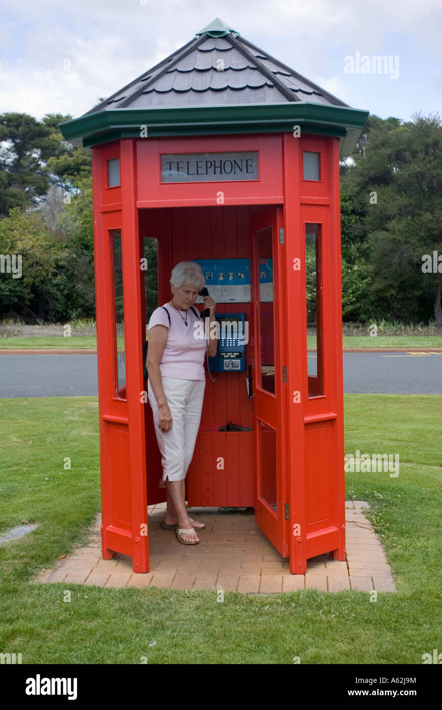 Woman phoning in old red telephone box Government Gardens Rotorua North ...