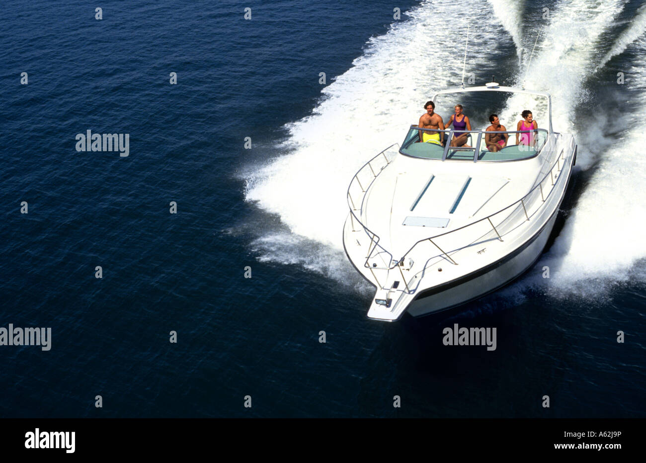 Couples running motor boat with wake and excitement as it moves thru ...