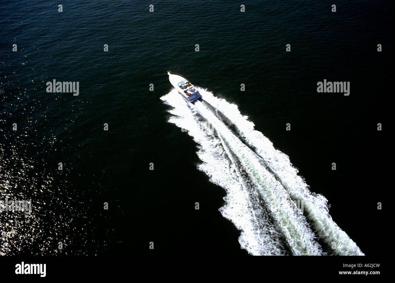 Couples running motor boat with wake and excitement as it moves thru ...