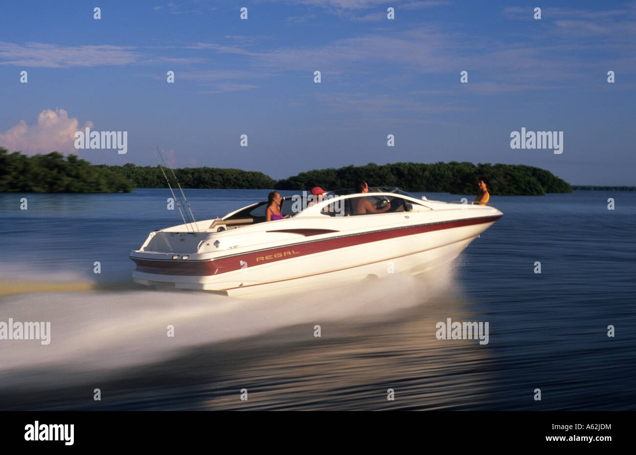 Couples running motor boat with wake and excitement as it moves thru ...