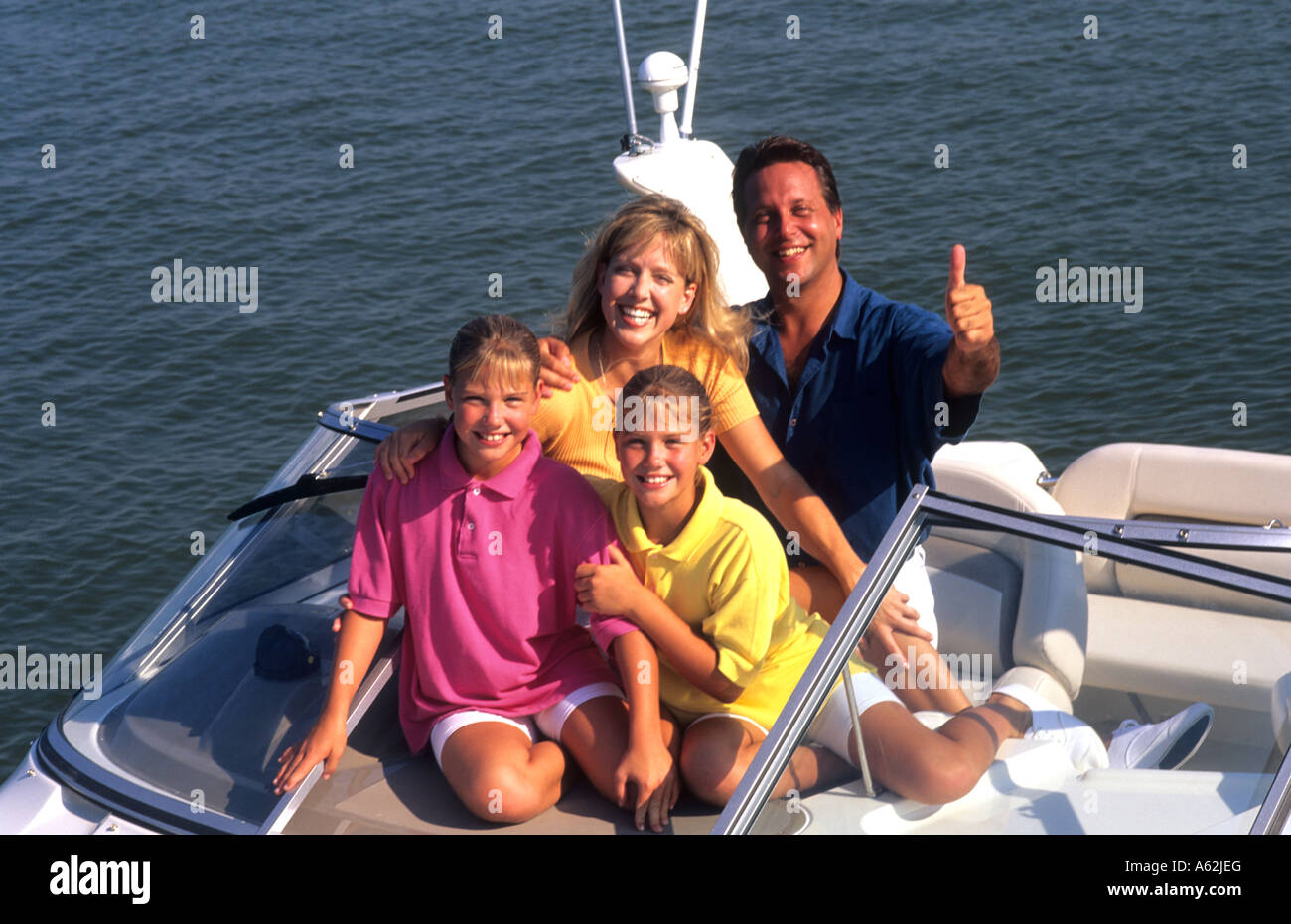 Portrait of happy family on motor boat having fun and relaxing outdoors ...