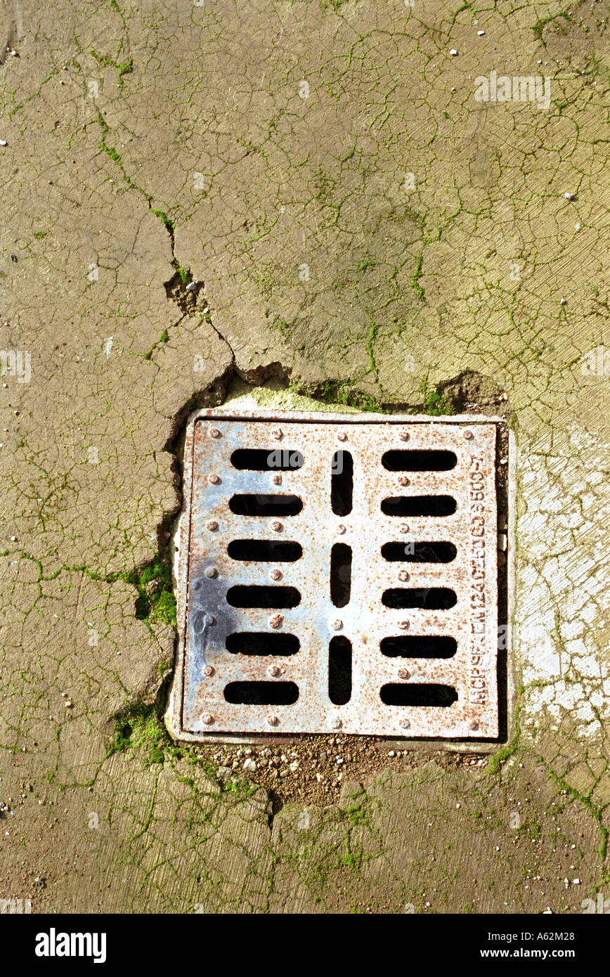 water drain and cracked road Stock Photo - Alamy
