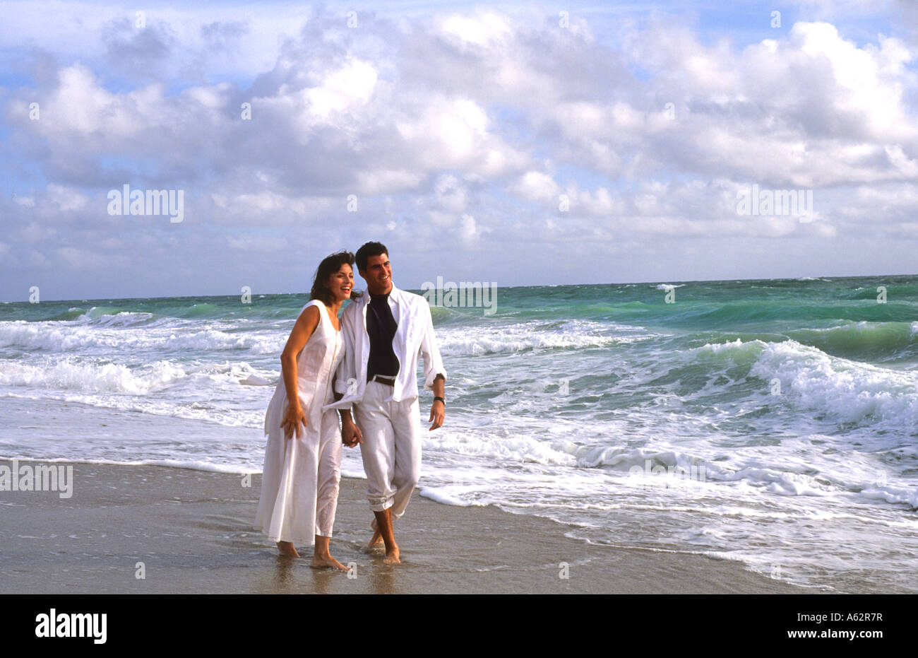 Romantic hispanic couple all dresed well relaxing on holiday at beach ...