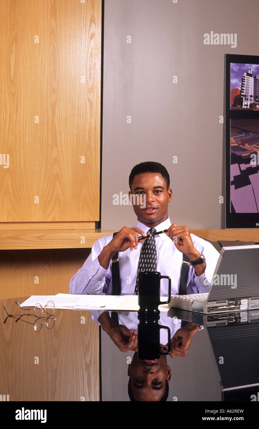 Attractive modern business man at desk in great setting in office ...