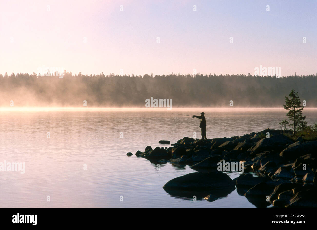 Silhouette of person fishing on lakeside Hedmark Norway Stock Photo - Alamy