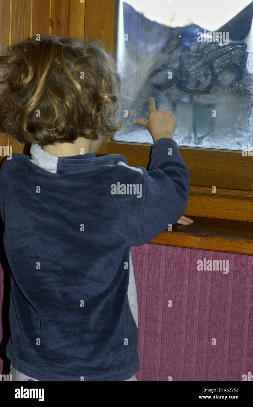 A four years old girl drawing on a foggy window Stock Photo - Alamy