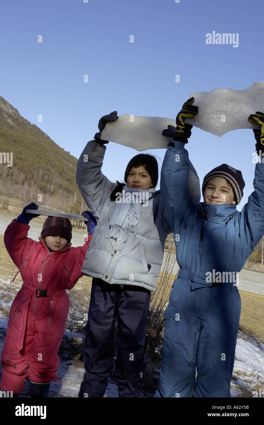 Three children holding a piece of ice as a trophy Stock Photo - Alamy