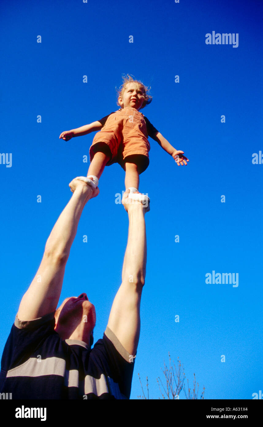 Father lifting up daughter low angle view Stock Photo - Alamy