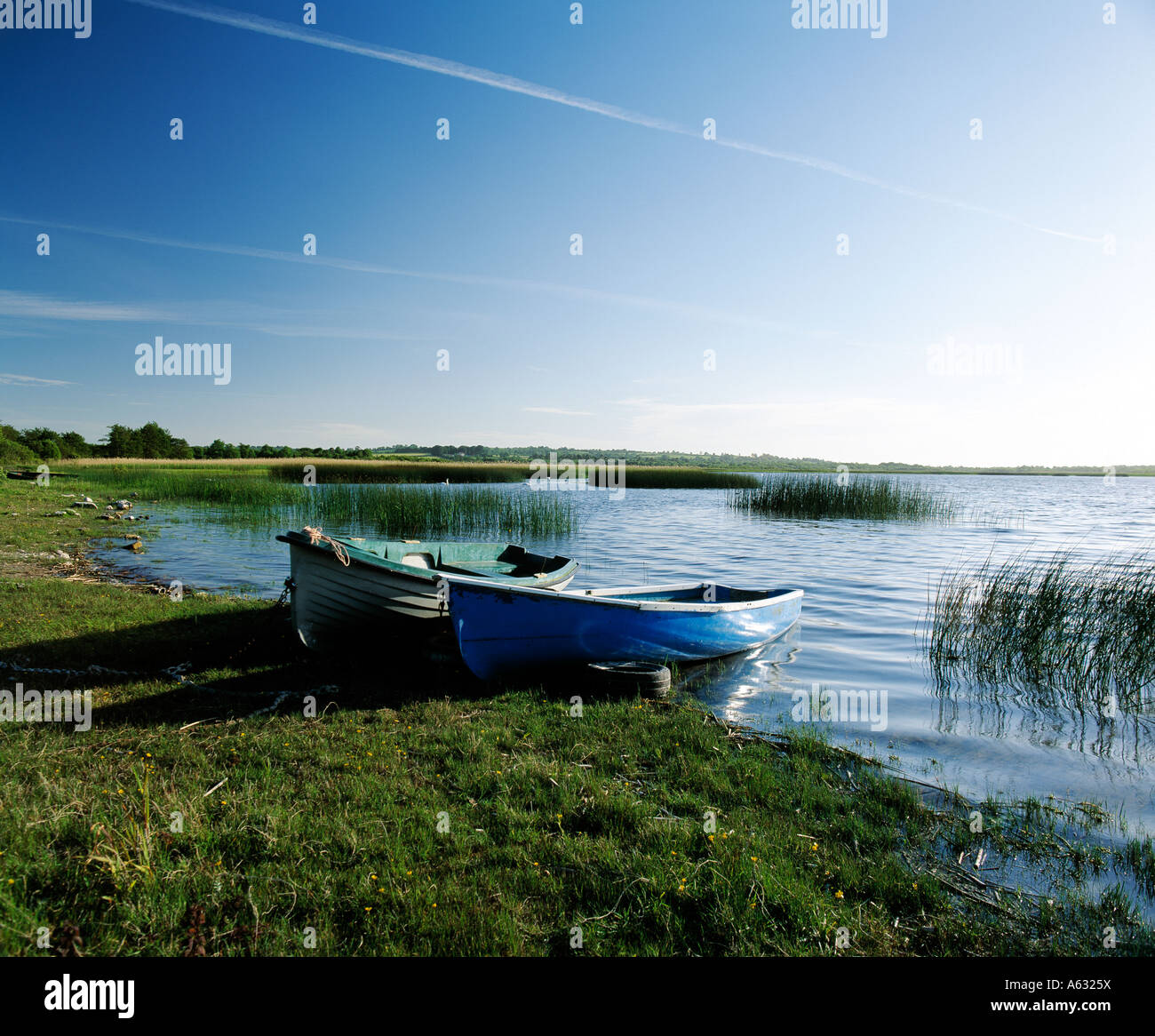 irish fresh water fishing lake with small boats sitting on the ...