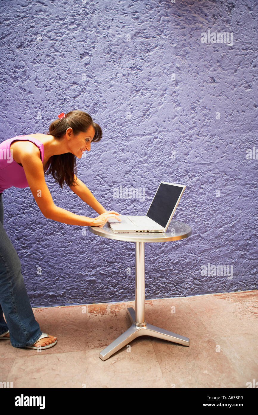 Side profile of a mid adult woman using a laptop Stock Photo - Alamy