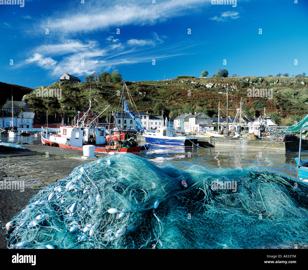 mounds of fishing nets sitting on a quay wall on irelands south coast ...