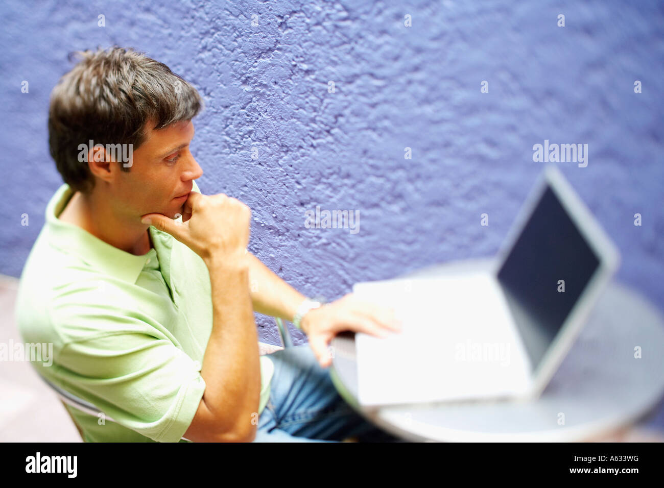 High angle view of a mid adult man looking at a laptop Stock Photo - Alamy