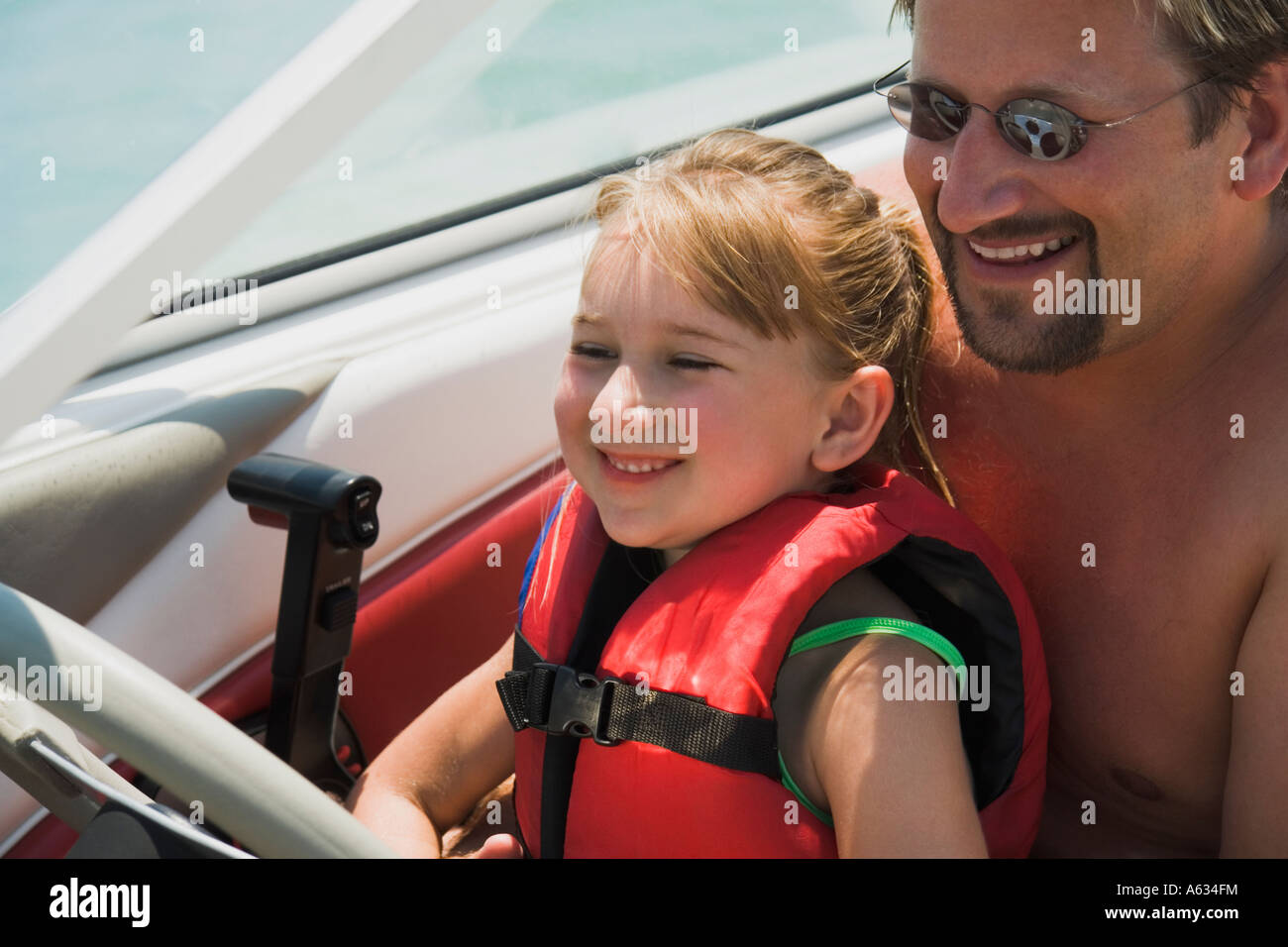 Father and daughter driving boat Stock Photo - Alamy