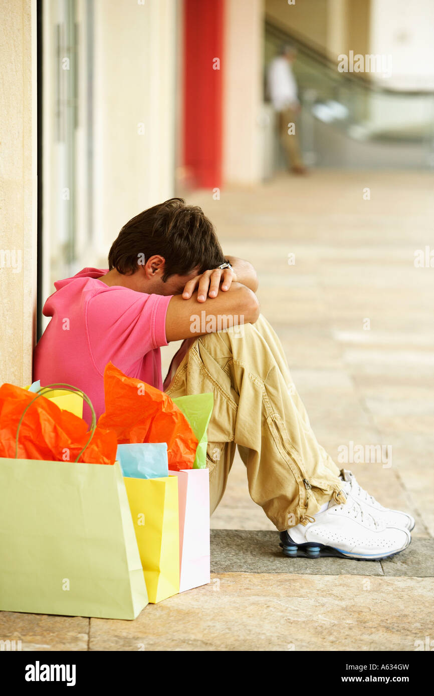 Side profile of a mid adult man resting his head on his knees Stock ...