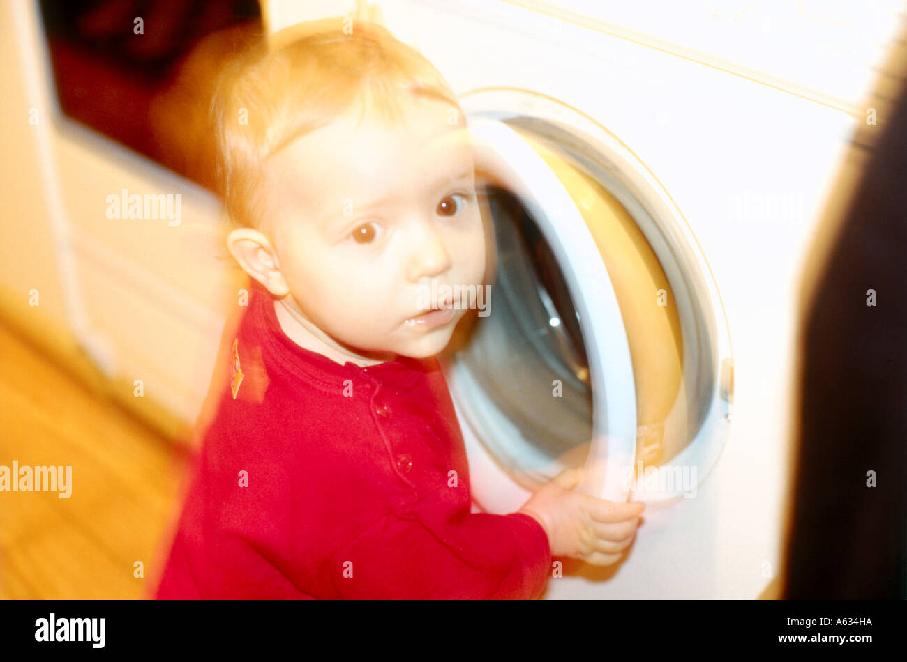 Boy standing beside washing machine, blurred Stock Photo - Alamy