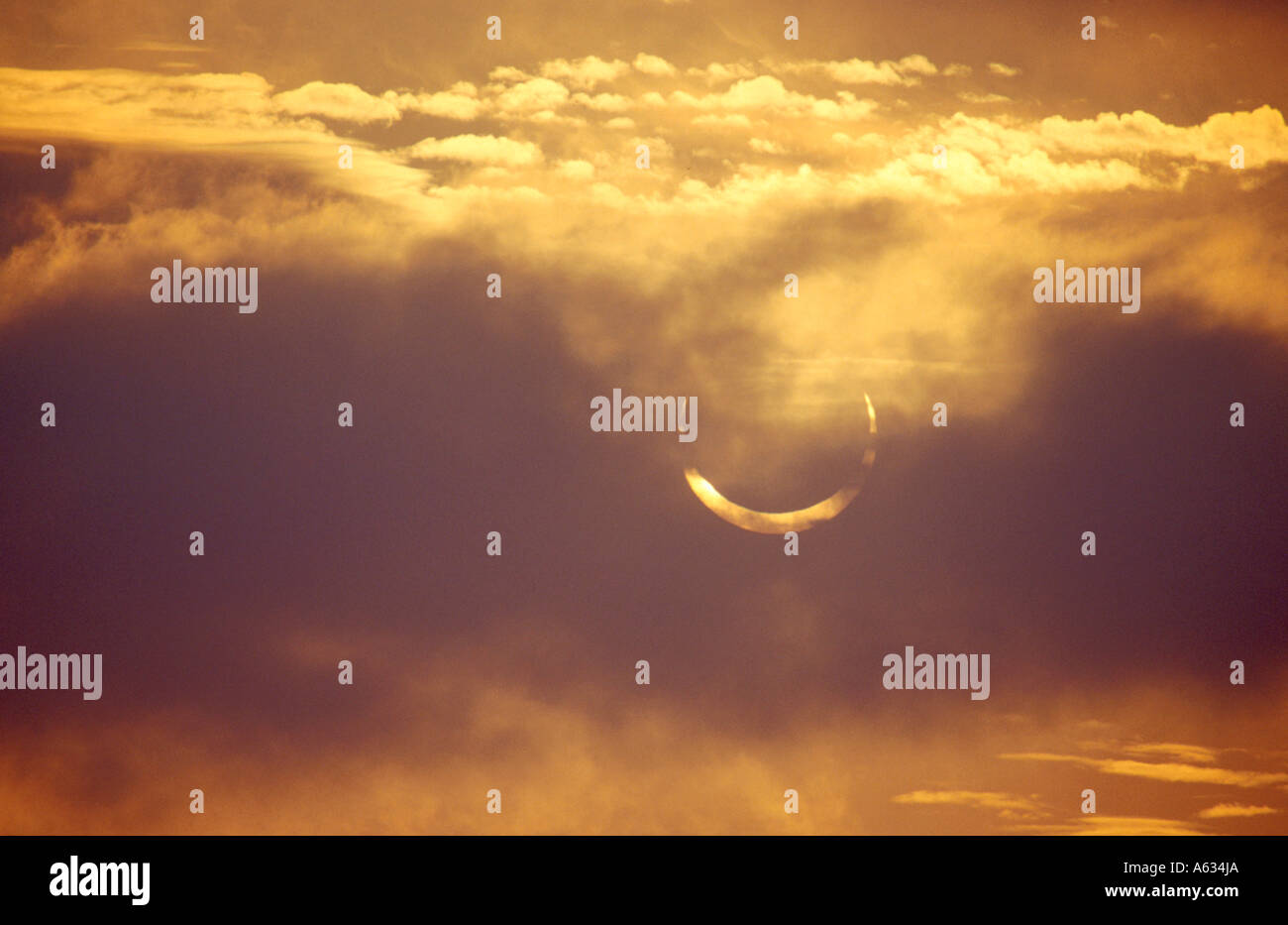 Solar eclipse behind clouds in sky Stock Photo - Alamy