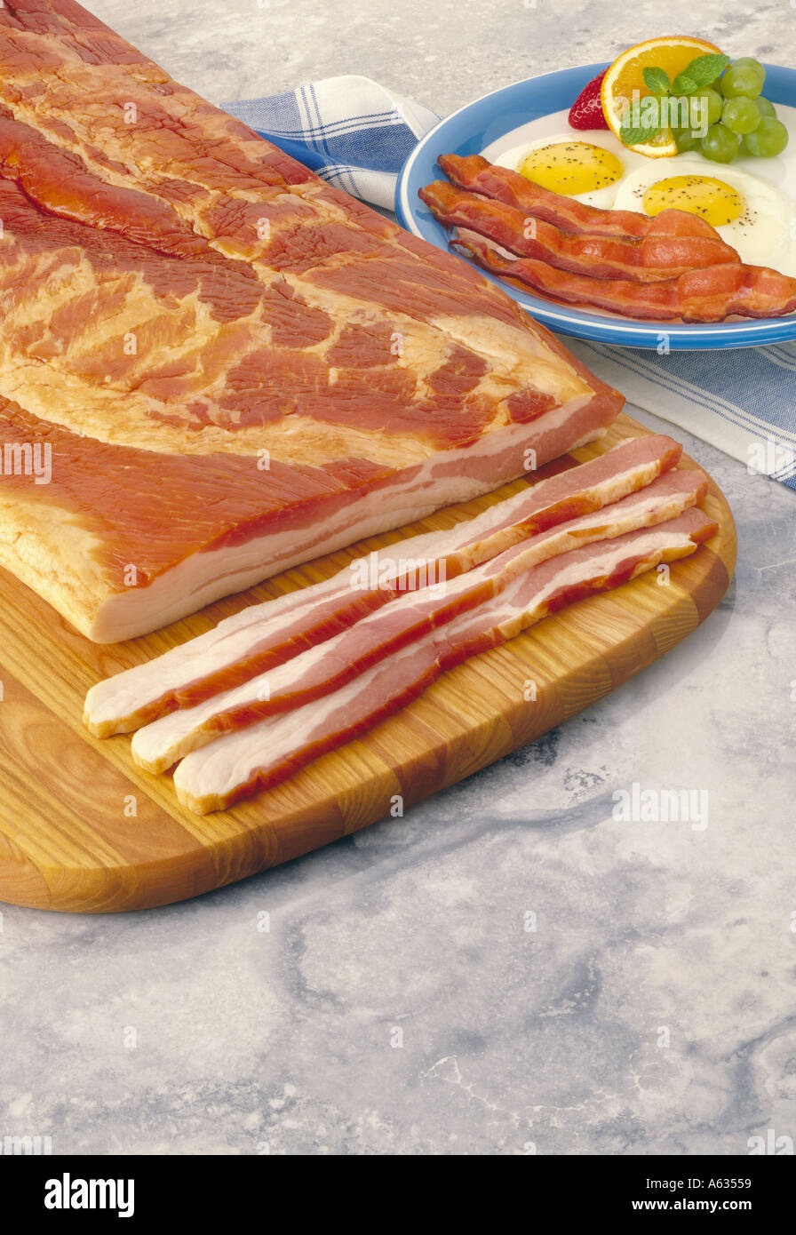 Bacon pork whole slab and sliced and prepared bacon and eggs plated ...