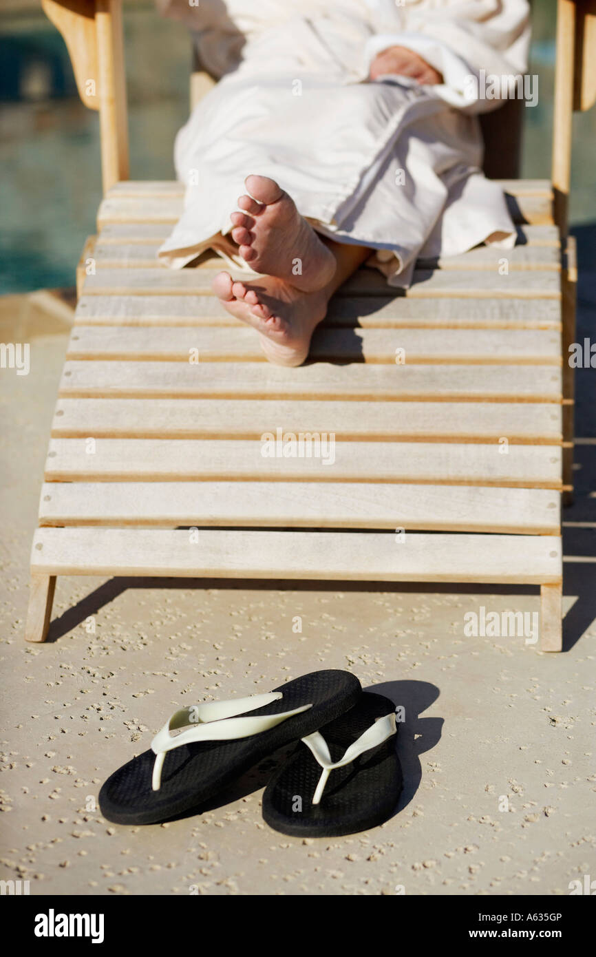 Low section view of a woman sitting on a lounge chair Stock Photo - Alamy