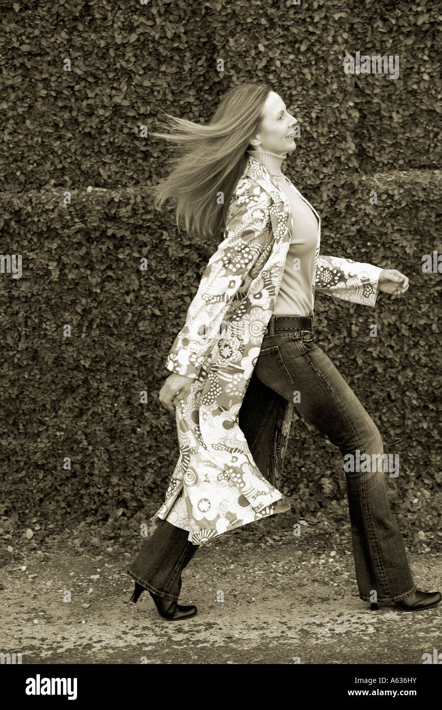 Side profile of a young woman walking on footpath Stock Photo - Alamy