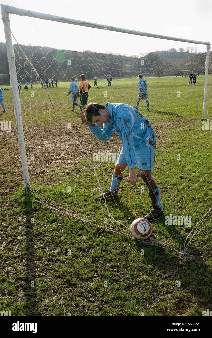 Sunday morning football a defender retrieving the ball from his own net ...