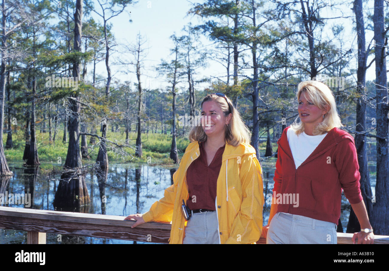 Two young beautiful blonde women in front of cypress trees in Black ...
